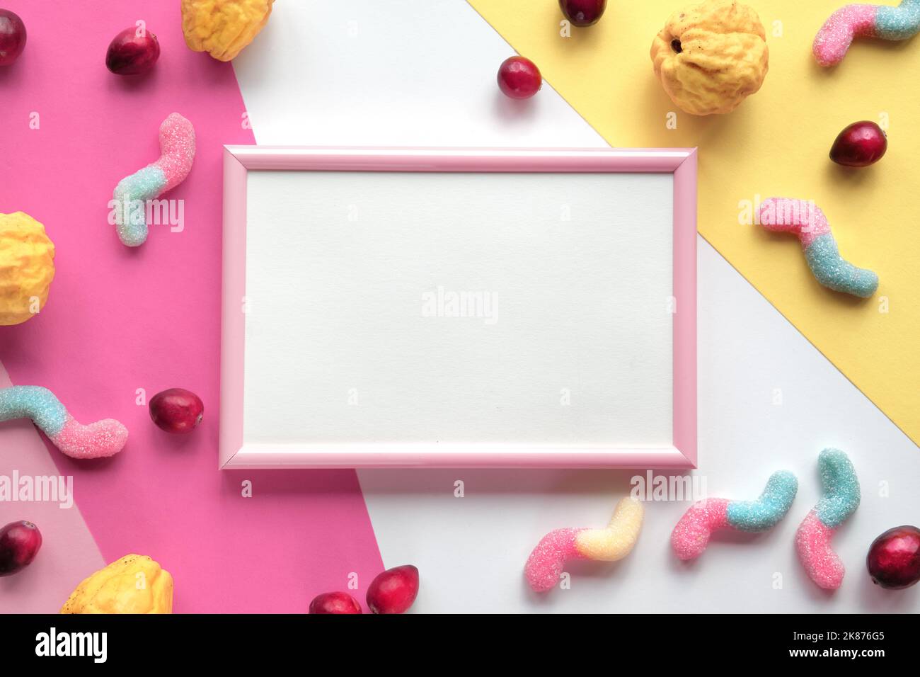 Blank pink white frame on layered colored paper. Assorted sweets ...