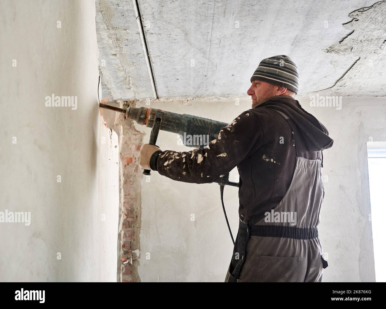 Male worker drilling wall with construction electric drill. Man using ...
