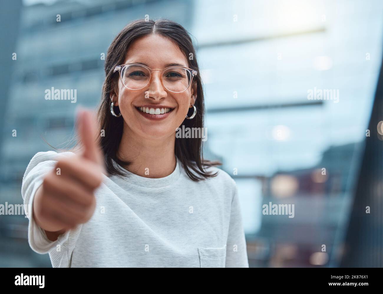 I knew you could do it. a young businesswoman showing thumbs up against ...