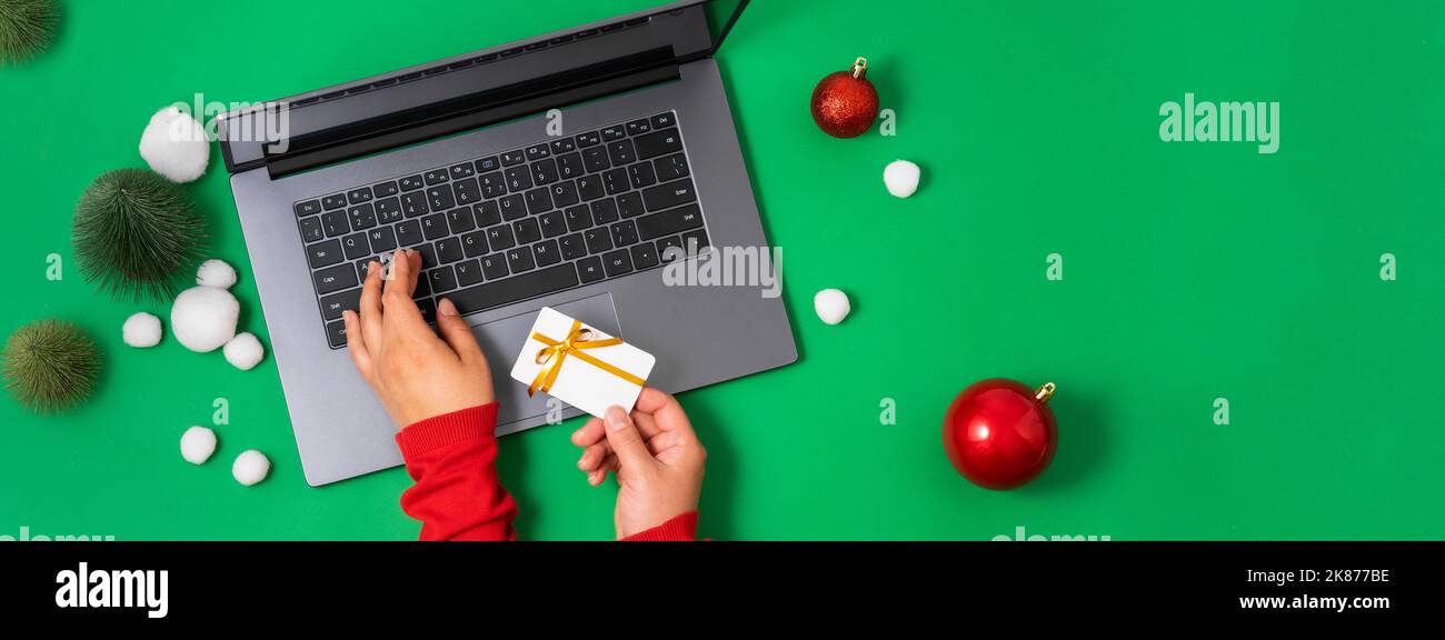 Female hands with bank, bonus card on laptop keyboard, top view on ...