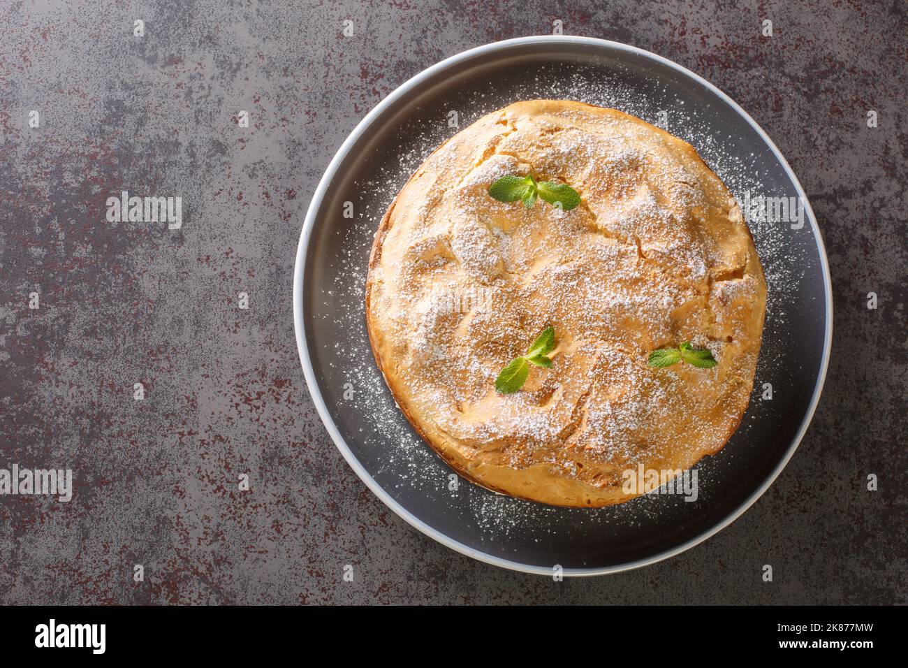 Large eclair Choux pastry cake with custard filling close-up in a plate ...