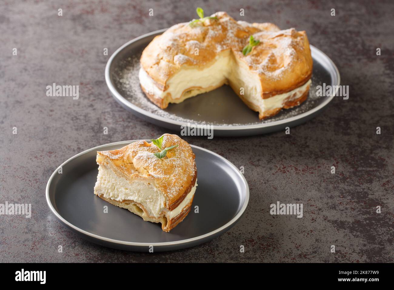 Large eclair Choux pastry cake with custard filling close-up in a plate ...