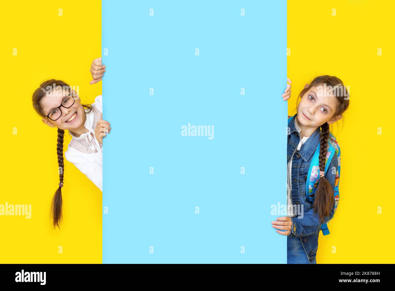 Girls sisters holding blue empy poster and smiling. two little girls ...