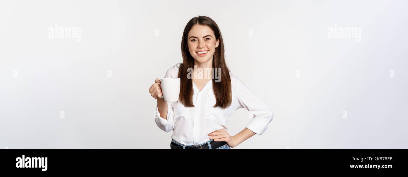 Young moder business woman, office lady holding mug with coffee tea and ...
