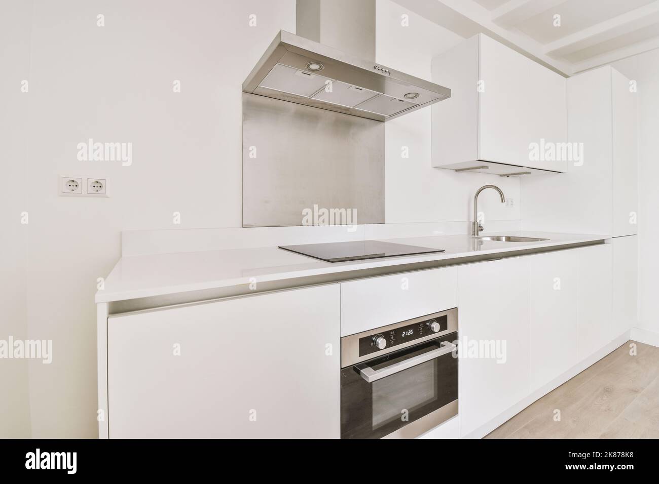 Interior of empty white kitchen with windows and wooden parquet floor ...