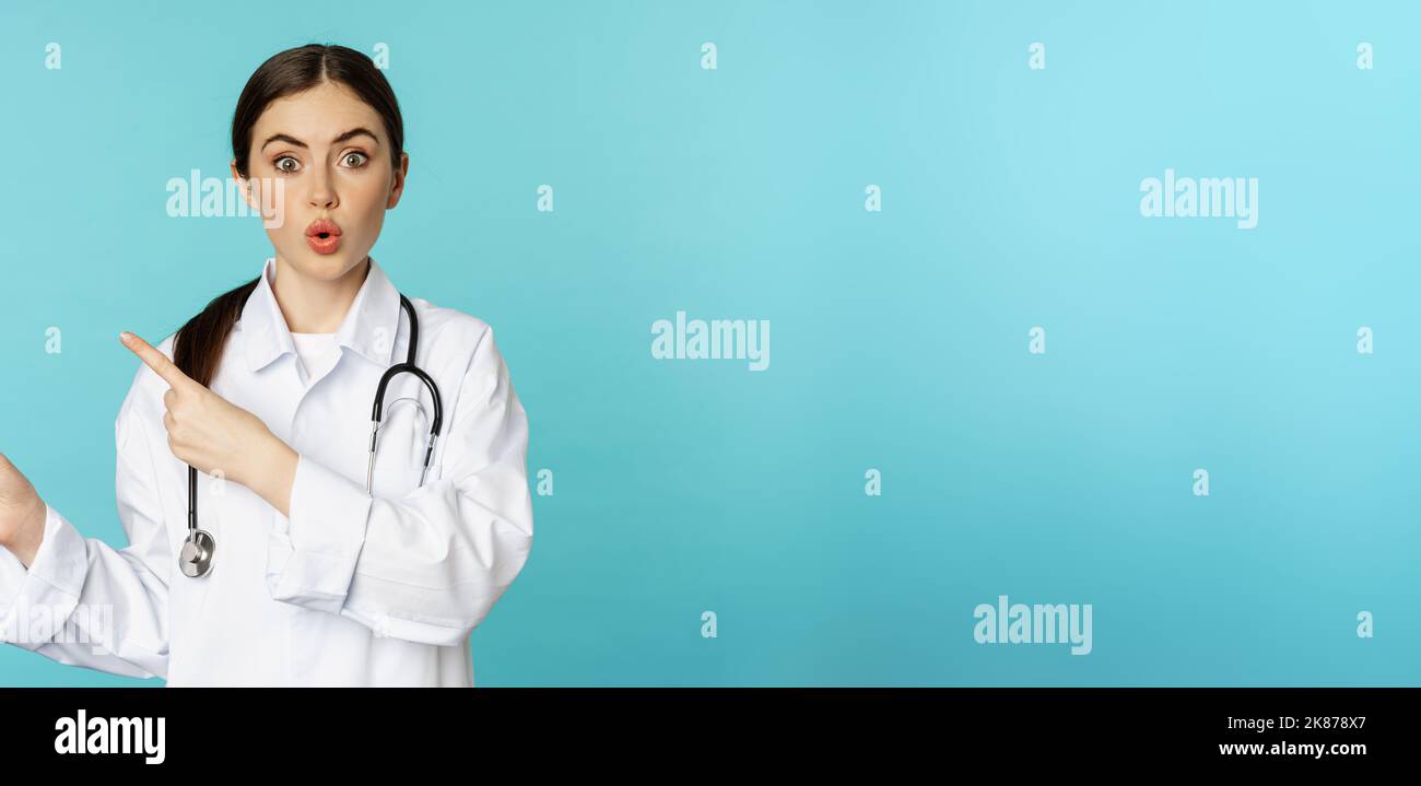 Portrait of smiling medical worker, girl doctor in white coat with ...