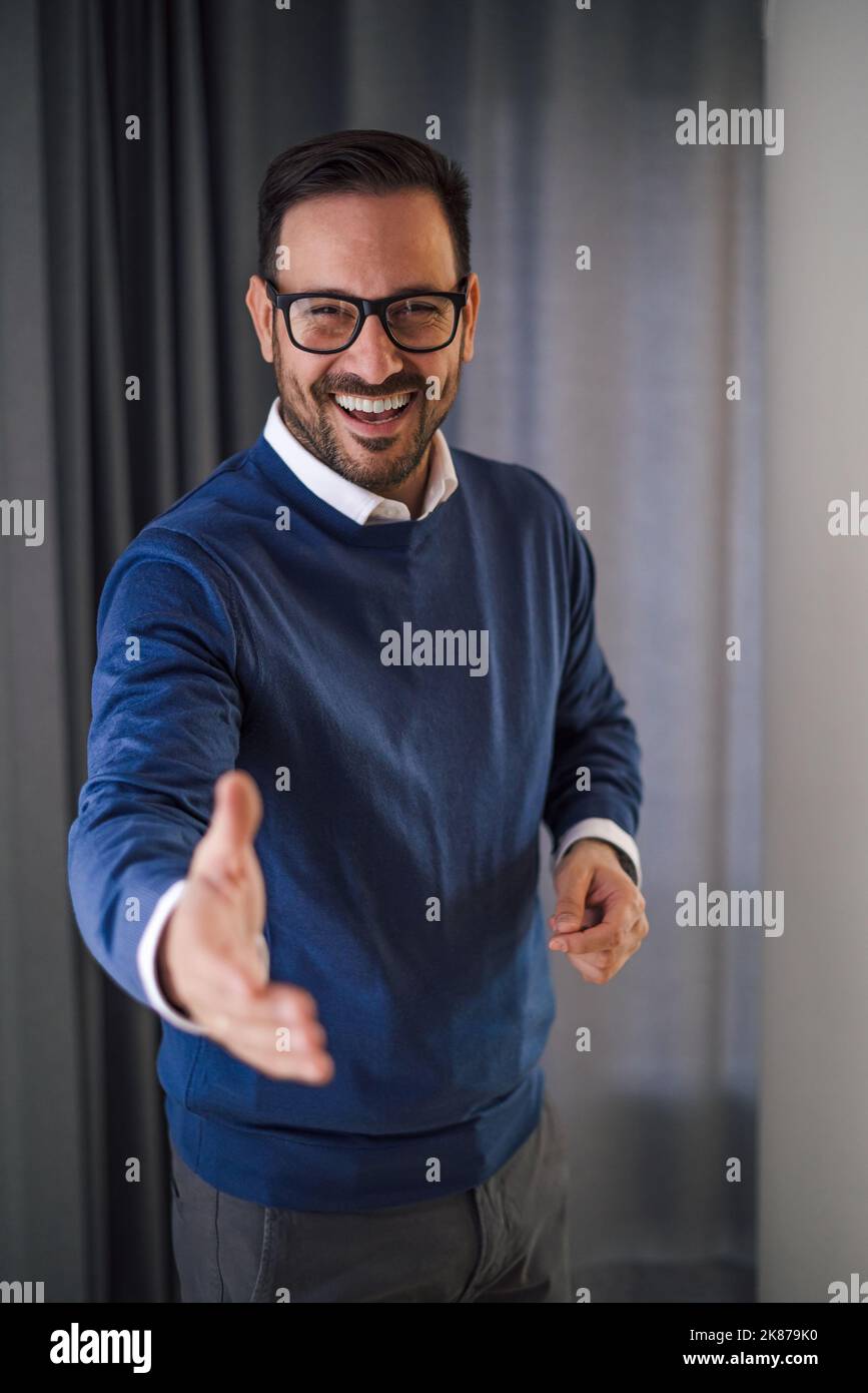 Picture of friendly company employee, offering a greeting, smiling for ...
