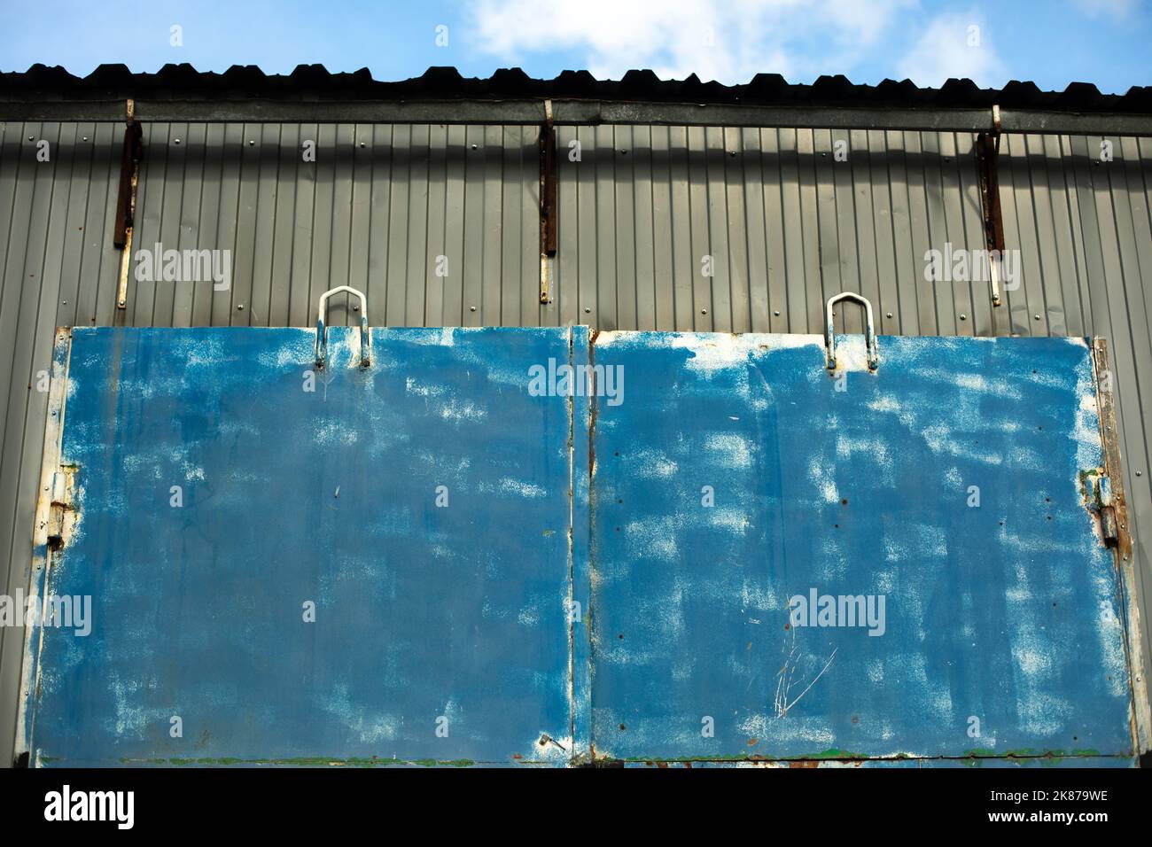 Old blue gate. Details of industrial area. Truck transport. Blue steel ...