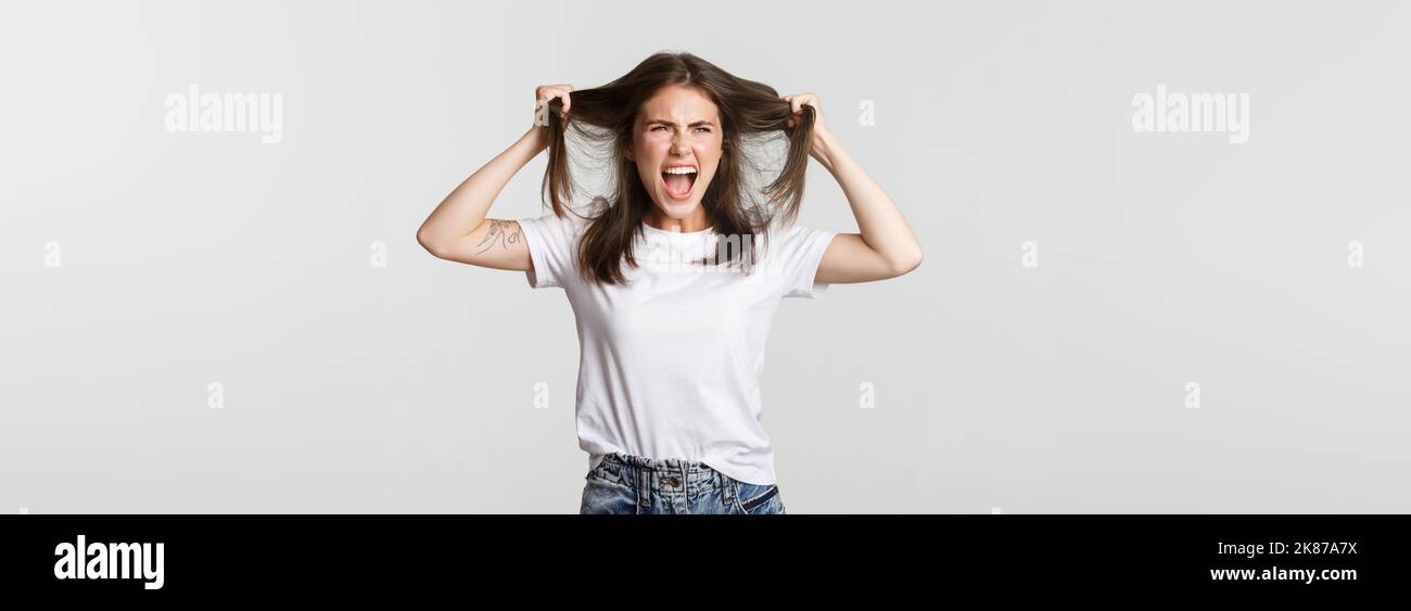 Outraged mad young woman ripping hair on head and yelling angry Stock ...