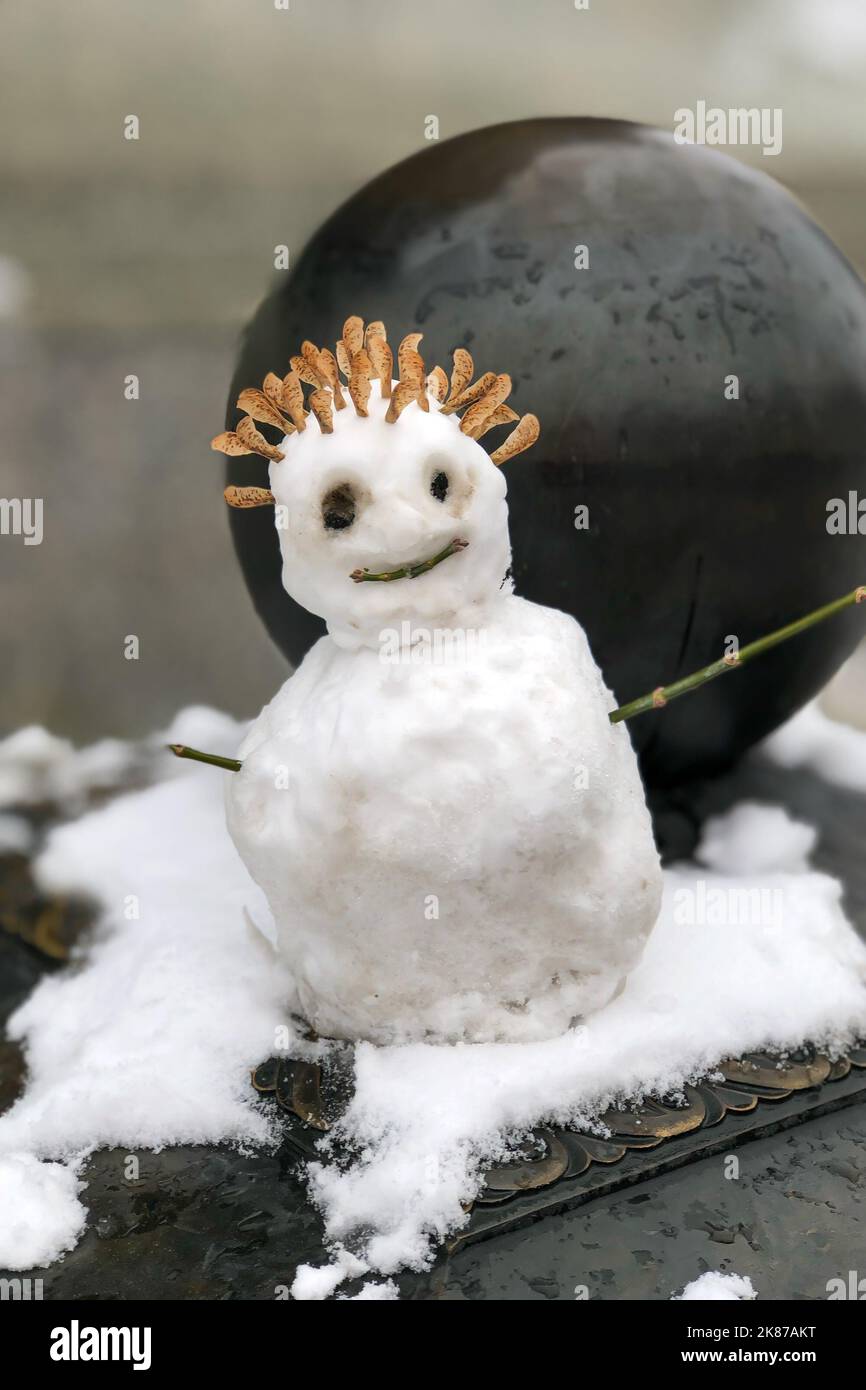 Cute little snowman made of little snow fallen on metal fence in city ...