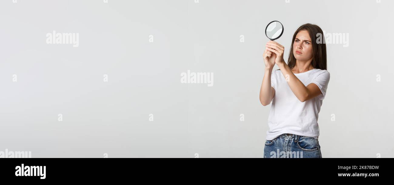 Serious-looking attractive young woman searching for something, looking ...