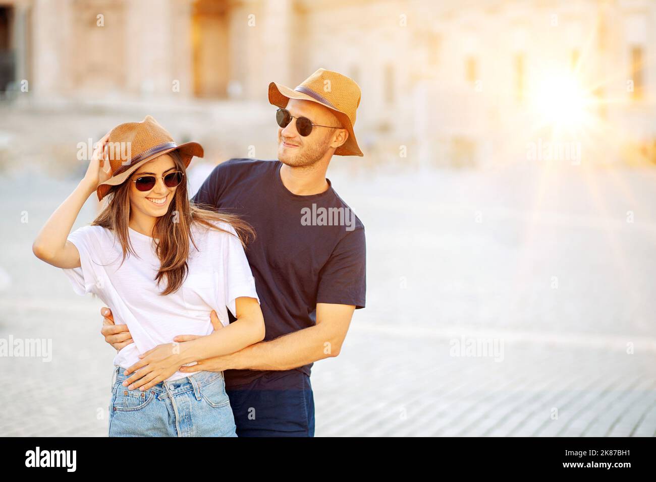 A young couple of travellers hugging in the city and enjoying romance ...