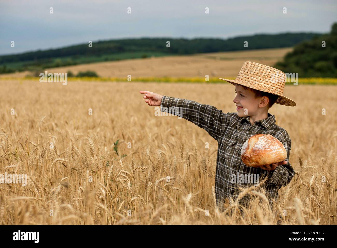 Little boy in the straw hat and shirt he held out his handing with ...