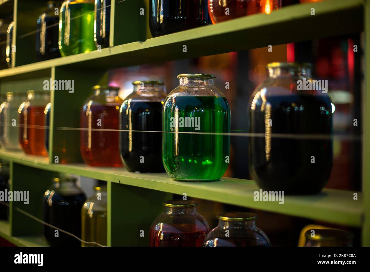Jars of colored water on shelves. Liquid in containers. Interior of ...