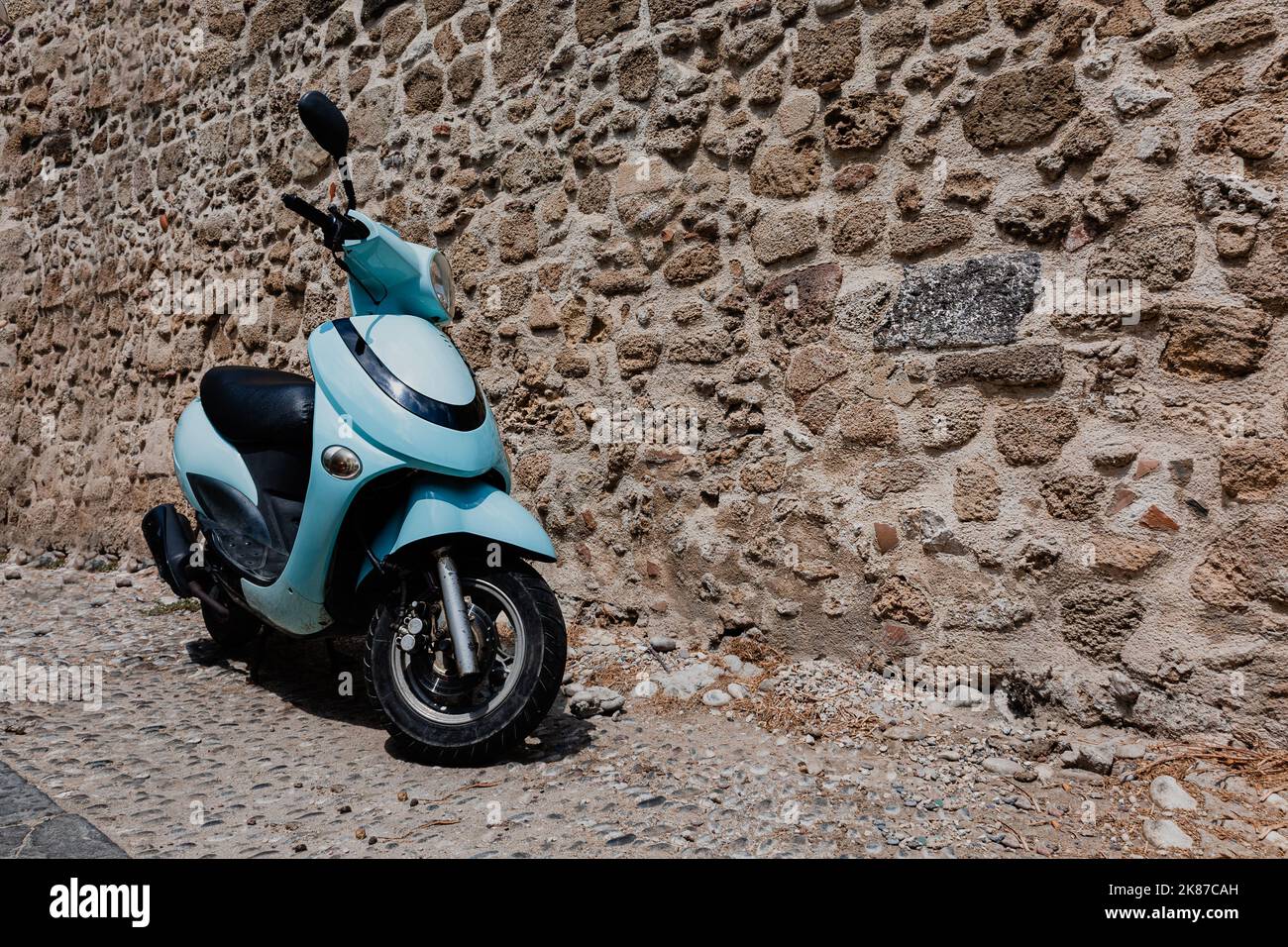 Narrow cobbled historical streets of Rhodes. Vintage scooter bike is ...