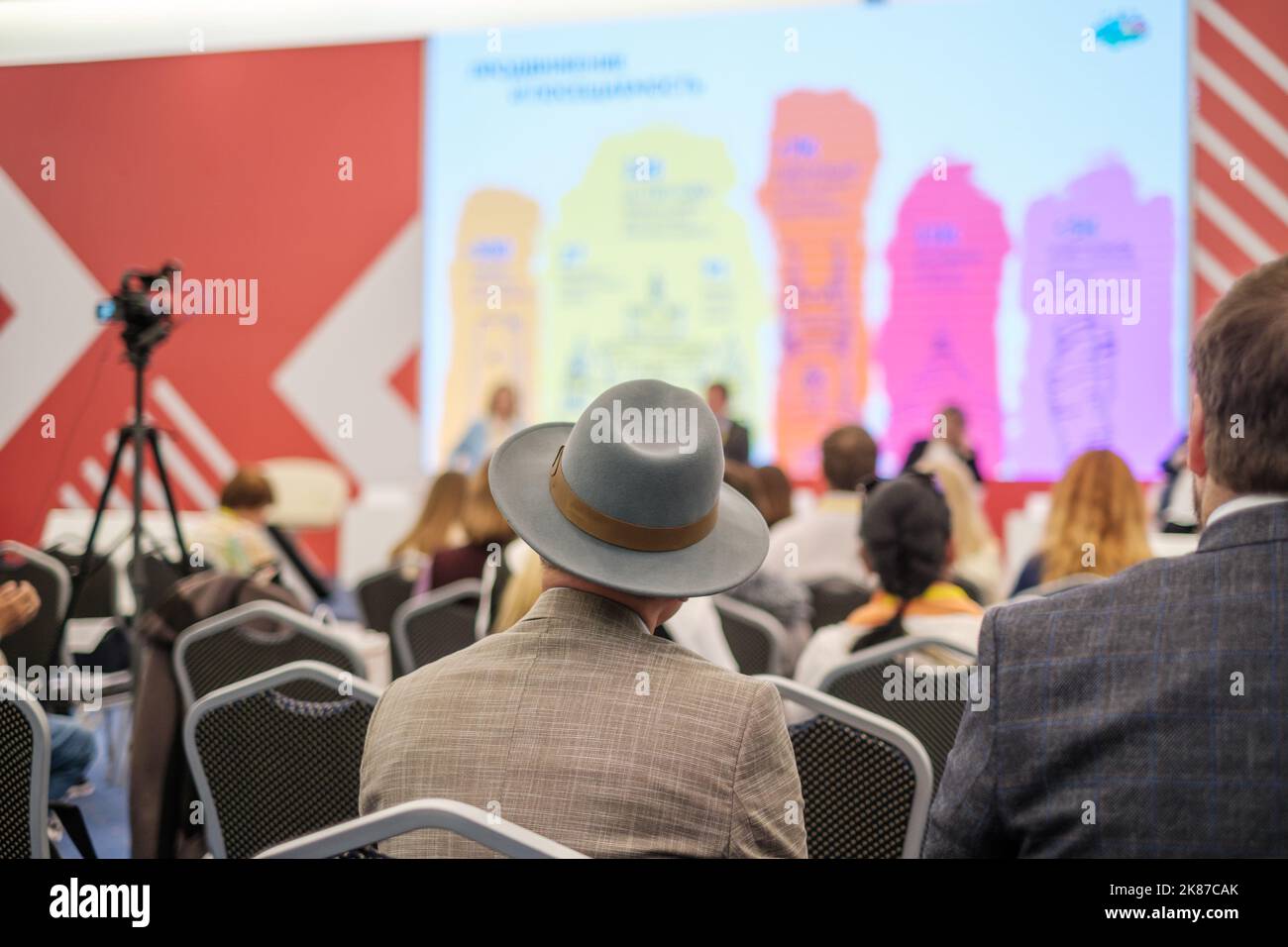 Group of people watching presentation on large screen and listening to ...