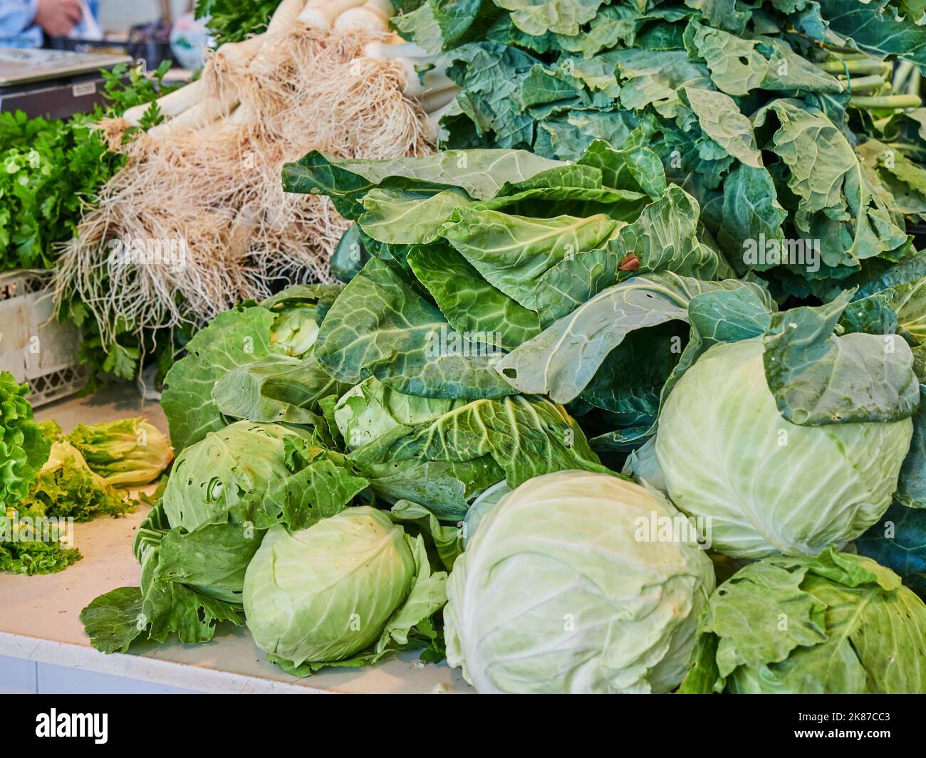 Kale, lettuce and cabbage piled up on a stall at the food market. Fresh ...