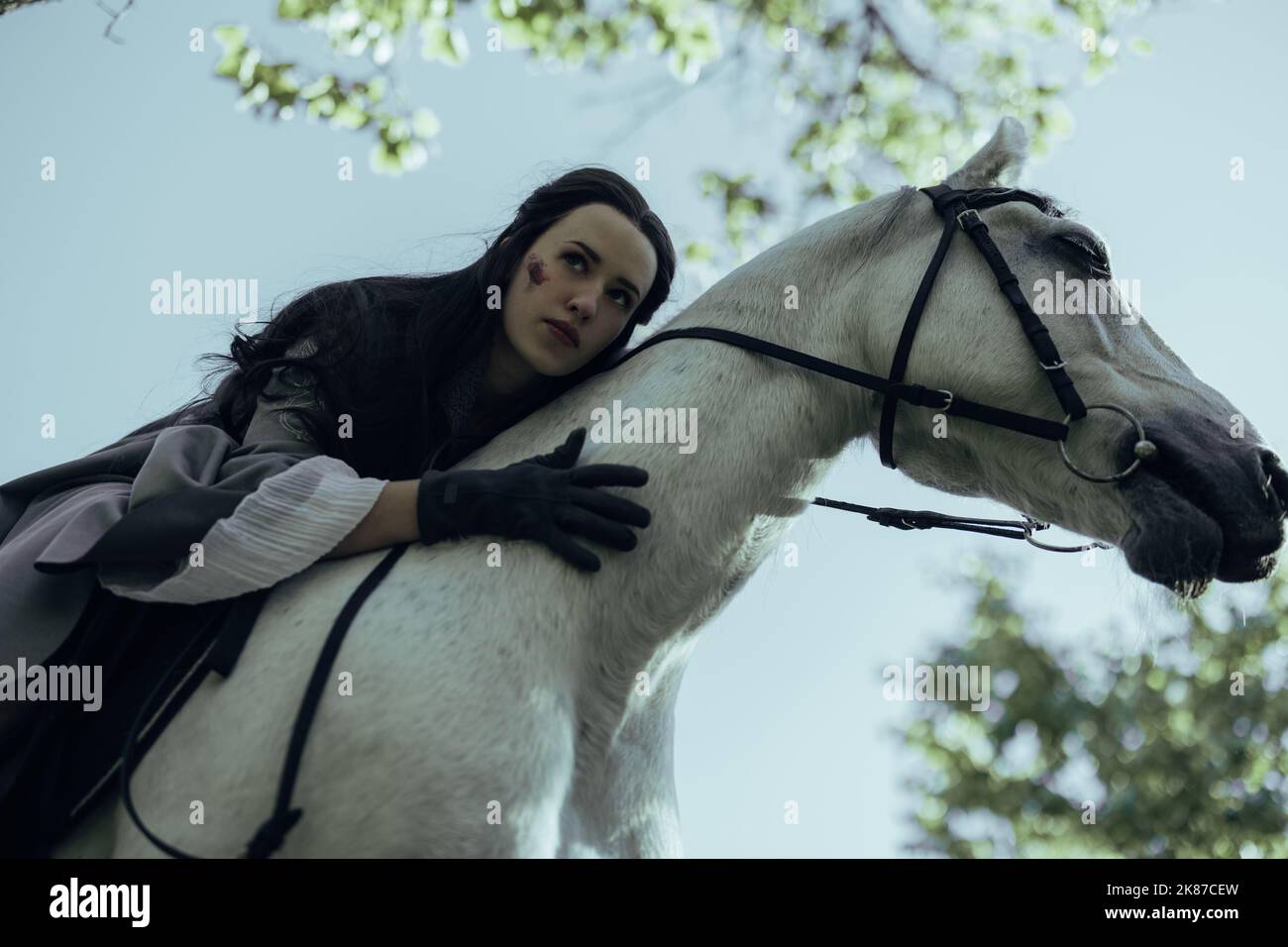 Young woman in image of ancient rider warrior sits on white horse and ...