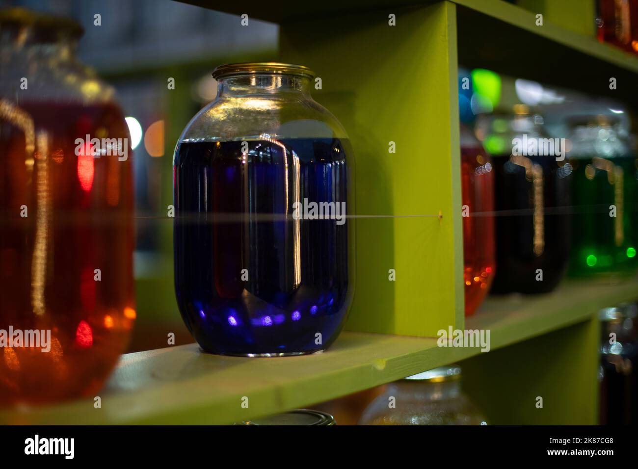 Jars of colored water on shelves. Liquid in containers. Interior of ...