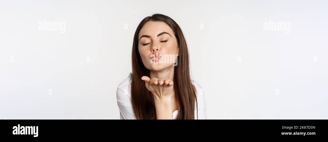 Feminine woman sending air kiss at camera, coquettish flirty pose ...