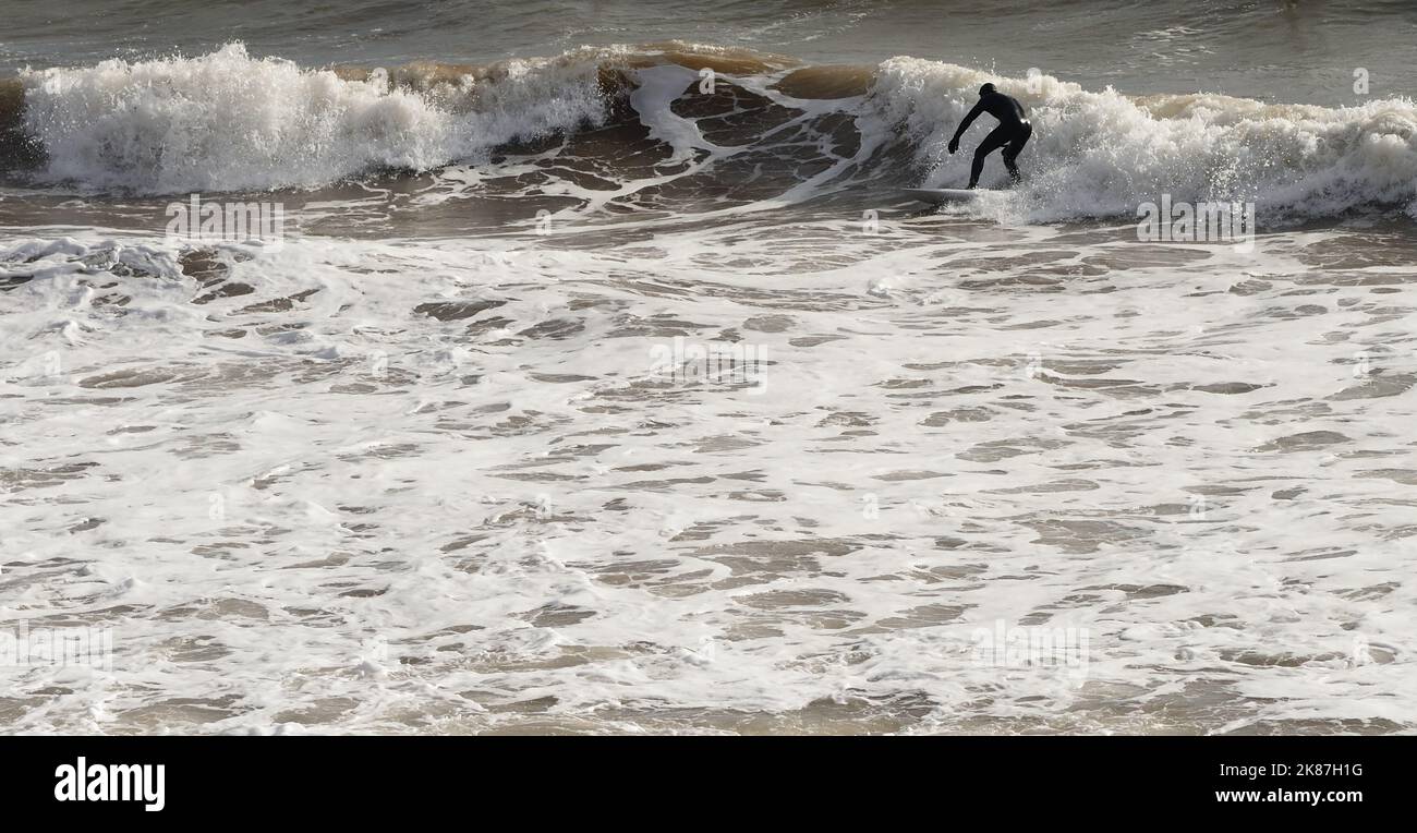 A surfer riding the waves at high tide Stock Photo - Alamy