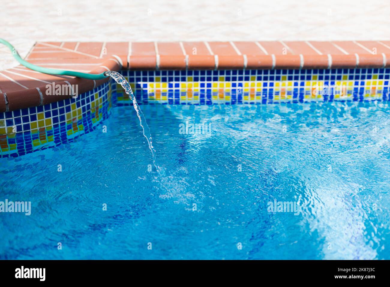Water pipe filling up swimming pool, closeup. Pool maintenance ...