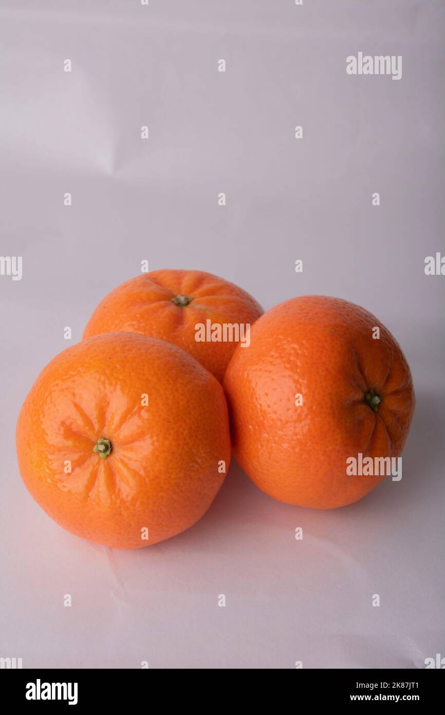 three tangerines lying on a white background Stock Photo - Alamy