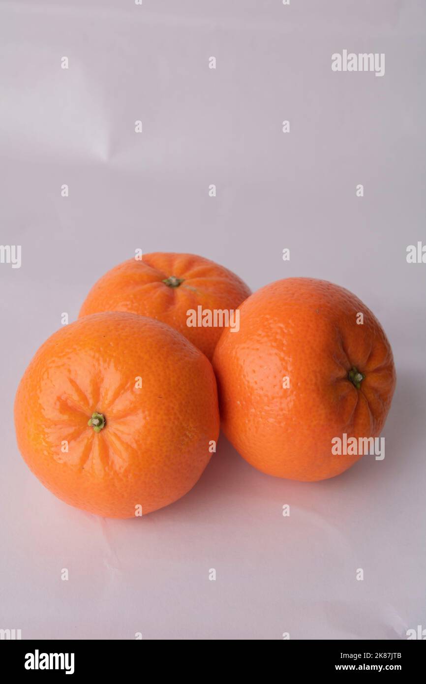 three tangerines lying on a white background Stock Photo - Alamy