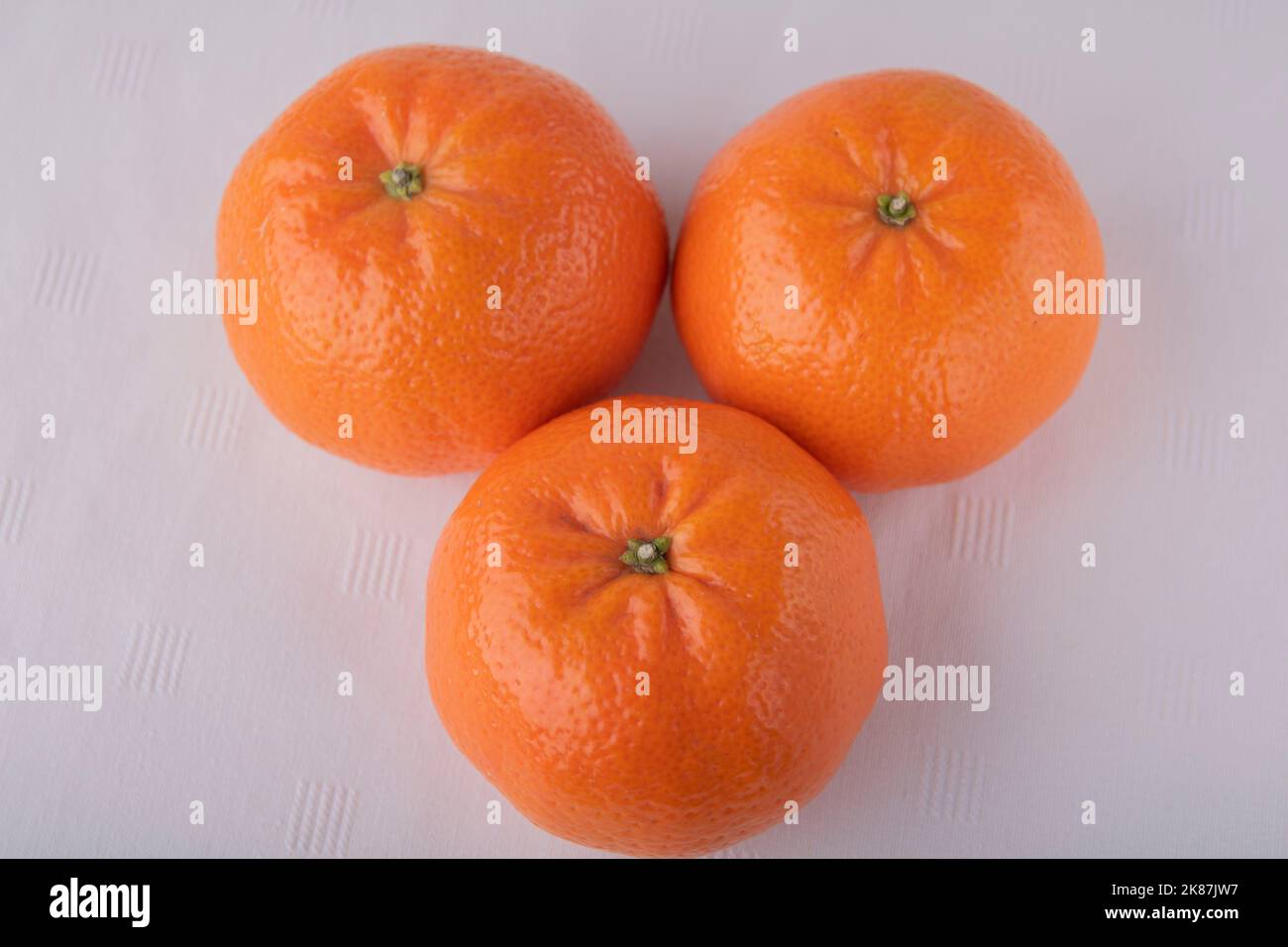 three tangerines lying on a white background Stock Photo - Alamy