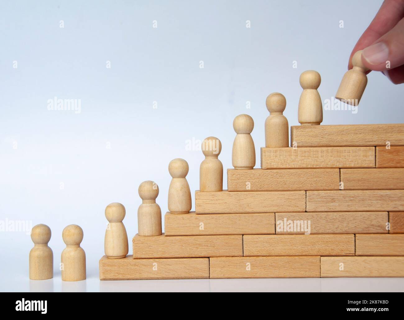 Wooden people figure on top of wooden blocks. Goal achievement ...