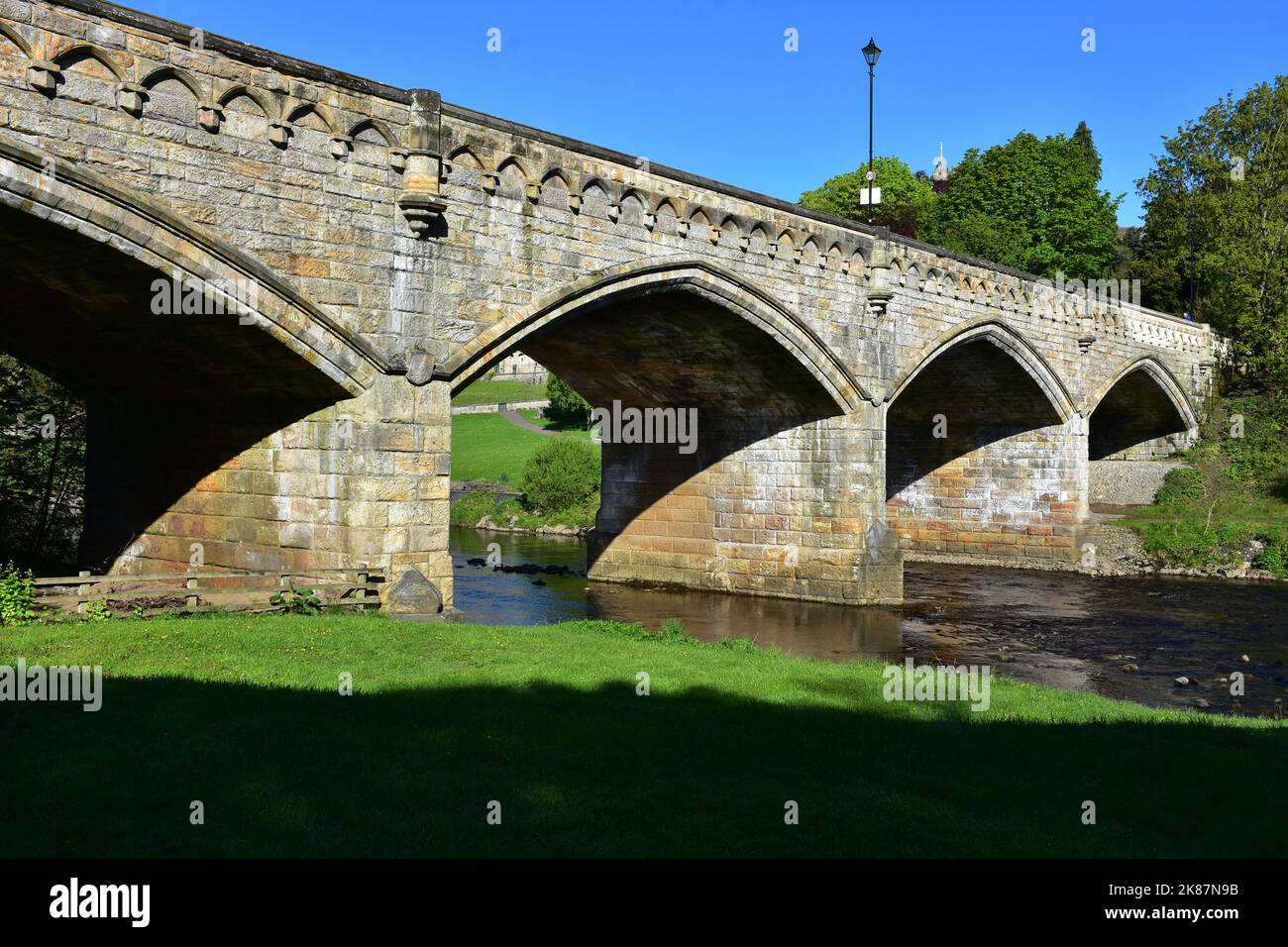 Stone arched bridge over a flowing river in England Stock Photo - Alamy