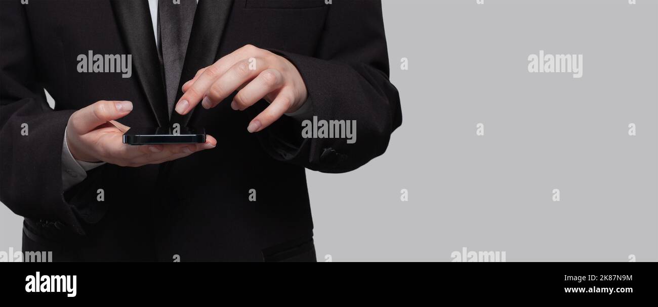 Business person works on mobile phone isolated on grey background Stock ...