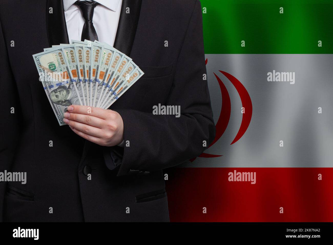 Iranian business man showing US 100 dollar bills against flag of Iran ...