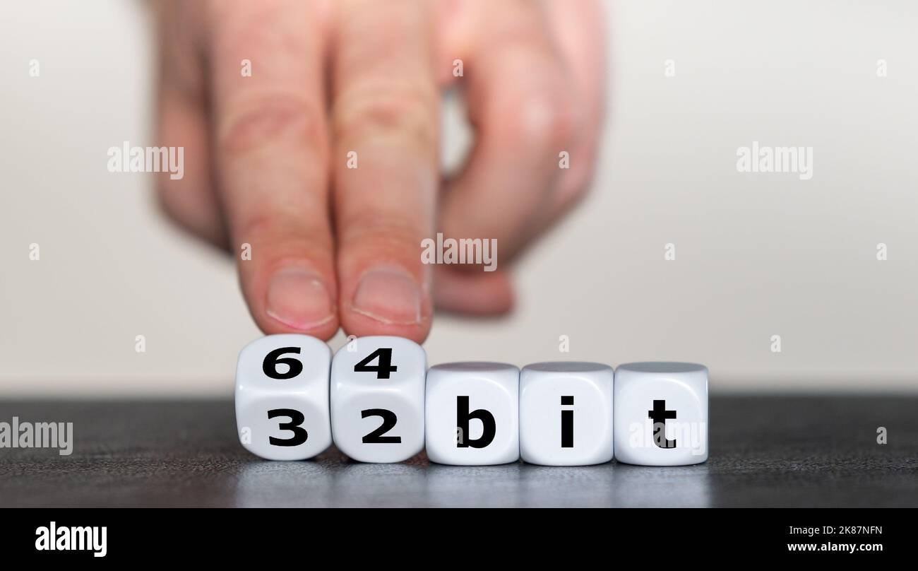 Hand turns dice and changes the expression '32 bit' to '64 bit' Stock ...