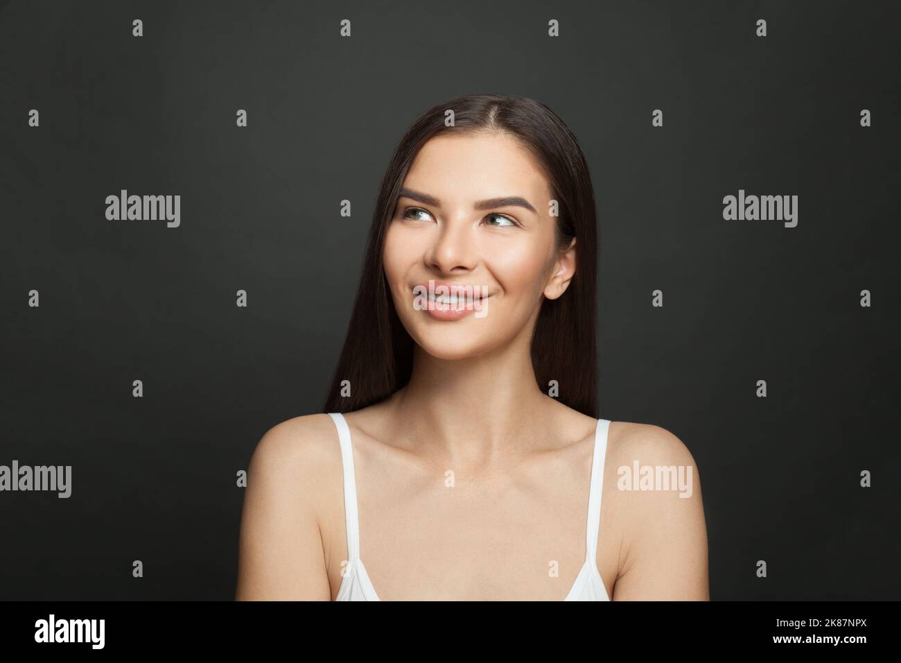 Cute female face. Pretty woman looking up and smiling on black ...