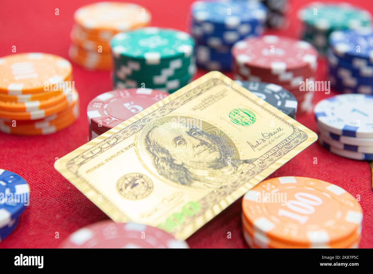 Top view of golden 100 dollar playing cards next to stacks of chips on ...