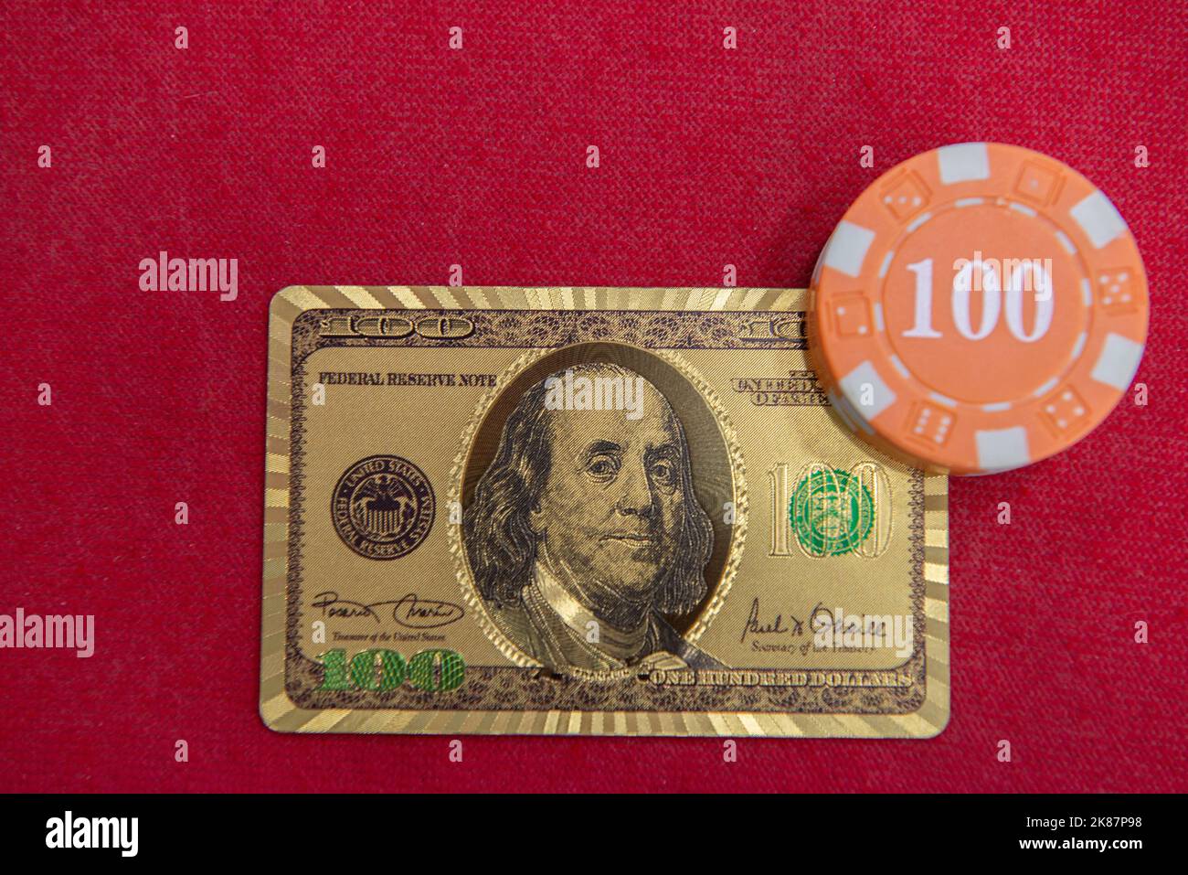 Top view of golden 100 dollar playing cards next to stacks of chips on ...