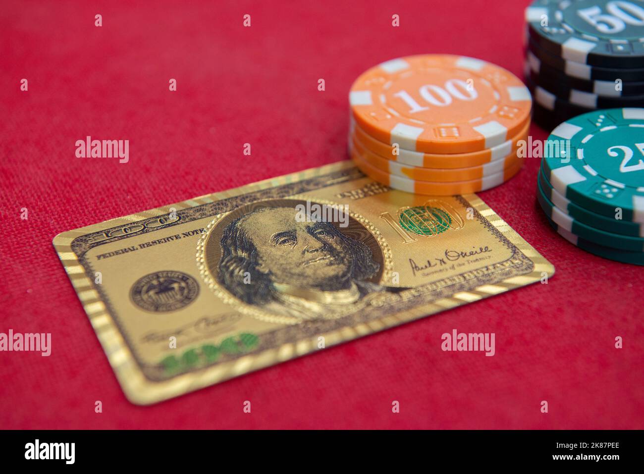 Top view of golden 100 dollar playing cards next to stacks of chips on ...