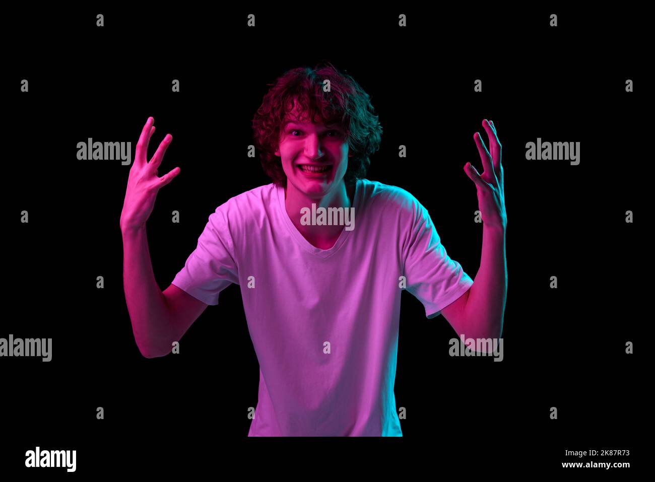 Looks angry. Half-length portrait of young man with negative facial ...