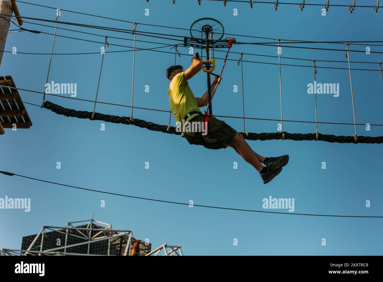 Adult man sitting on a pulley and rotating the wheel to go forward in ...