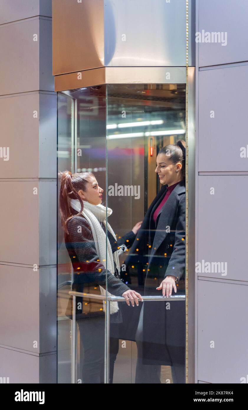 Two attractive and beautiful businesswomen are talking in the elevator Stock Photo - Alamy