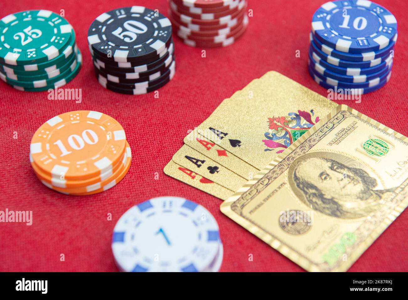 Four of aces near stacks of chips on a red felt table. Poker game is one of the most popular ...