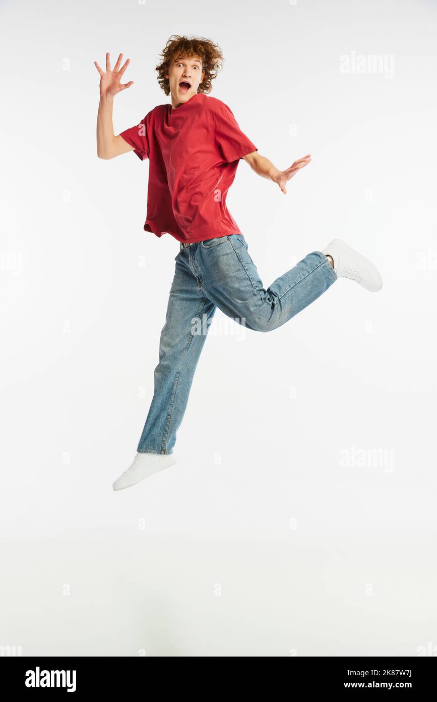 Full length portrait of excited young man jumping, dancing, having fun ...