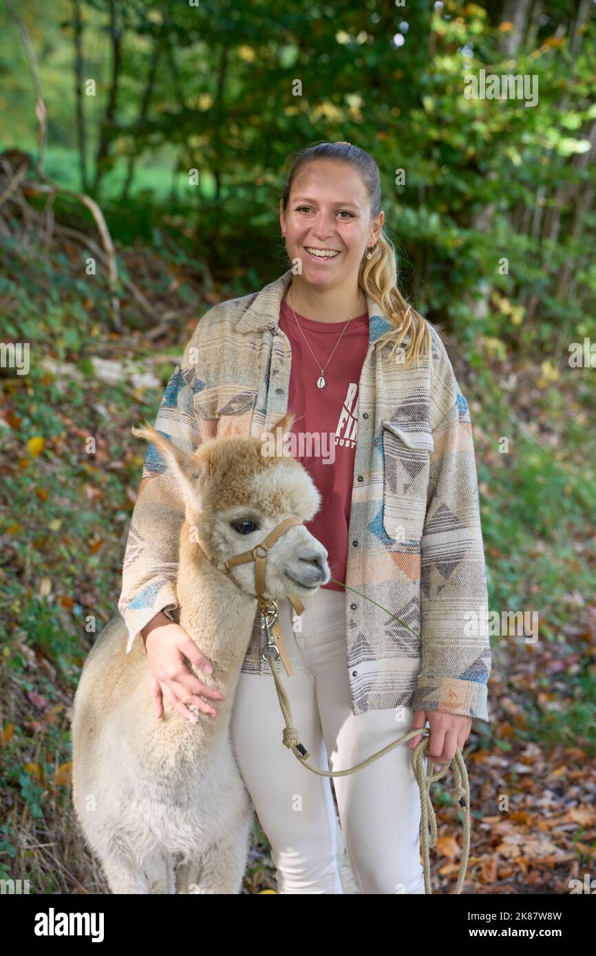 A Sunbeam Meets Young Woman With Beige Alpaca On Forest Path. In The ...