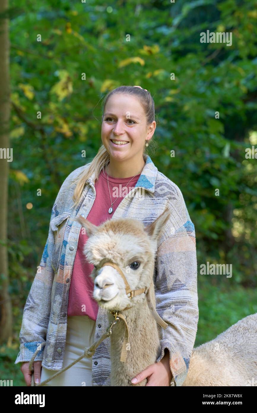 A Sunbeam Meets Young Woman With Beige Alpaca On Forest Path. In The ...