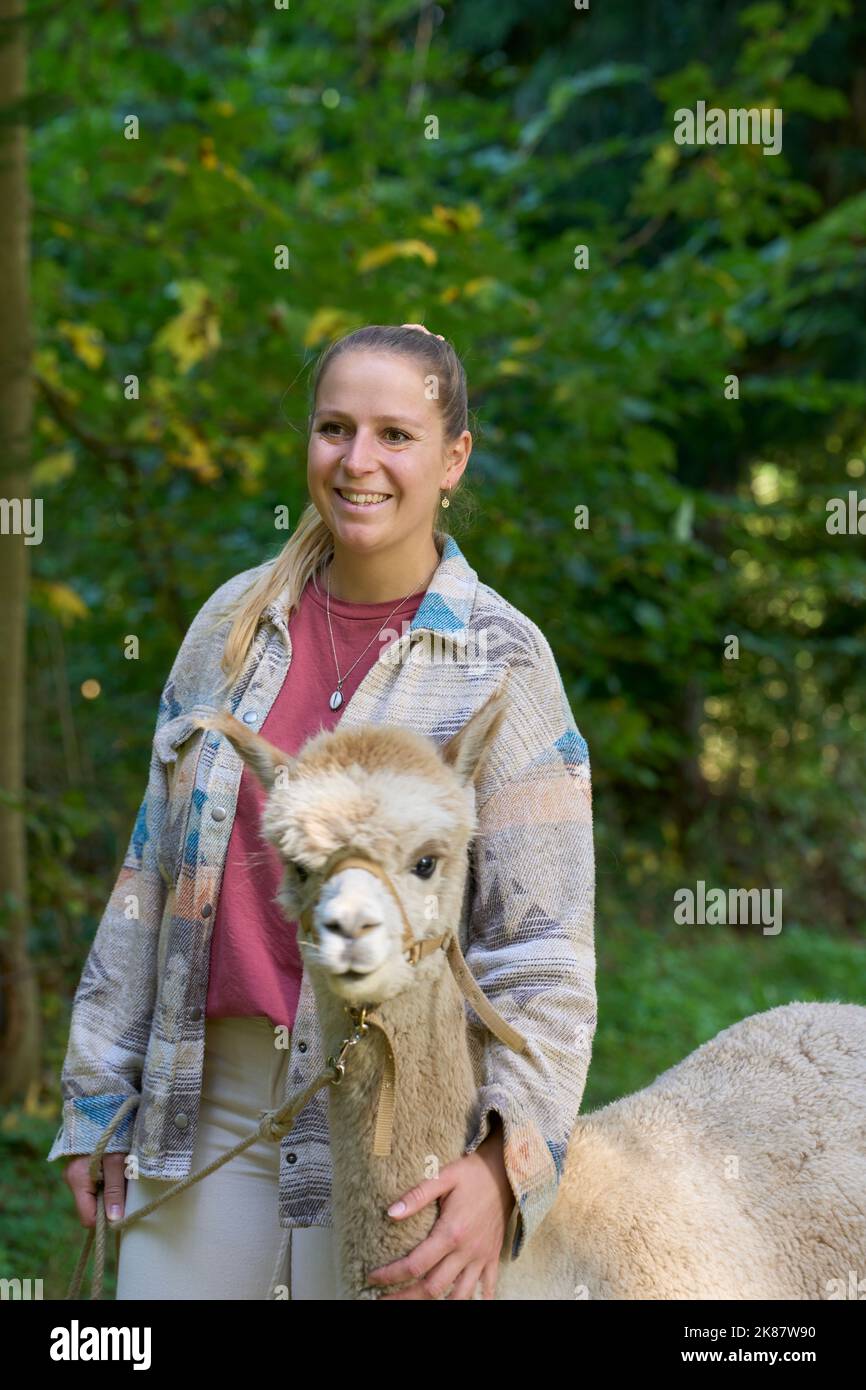 A Sunbeam Meets Young Woman With Beige Alpaca On Forest Path. In The ...
