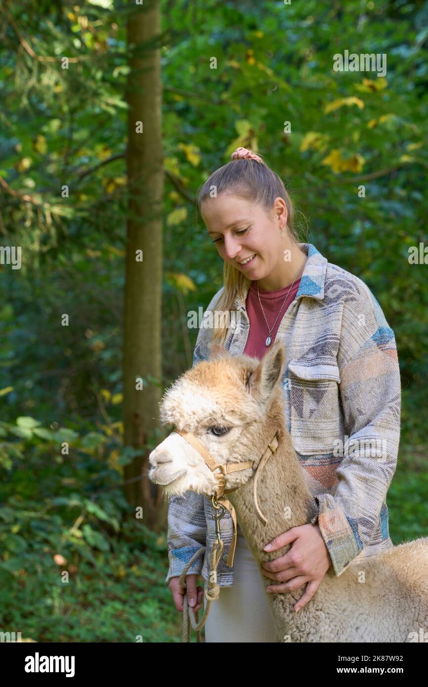 A Sunbeam Meets Young Woman With Beige Alpaca On Forest Path. In The ...