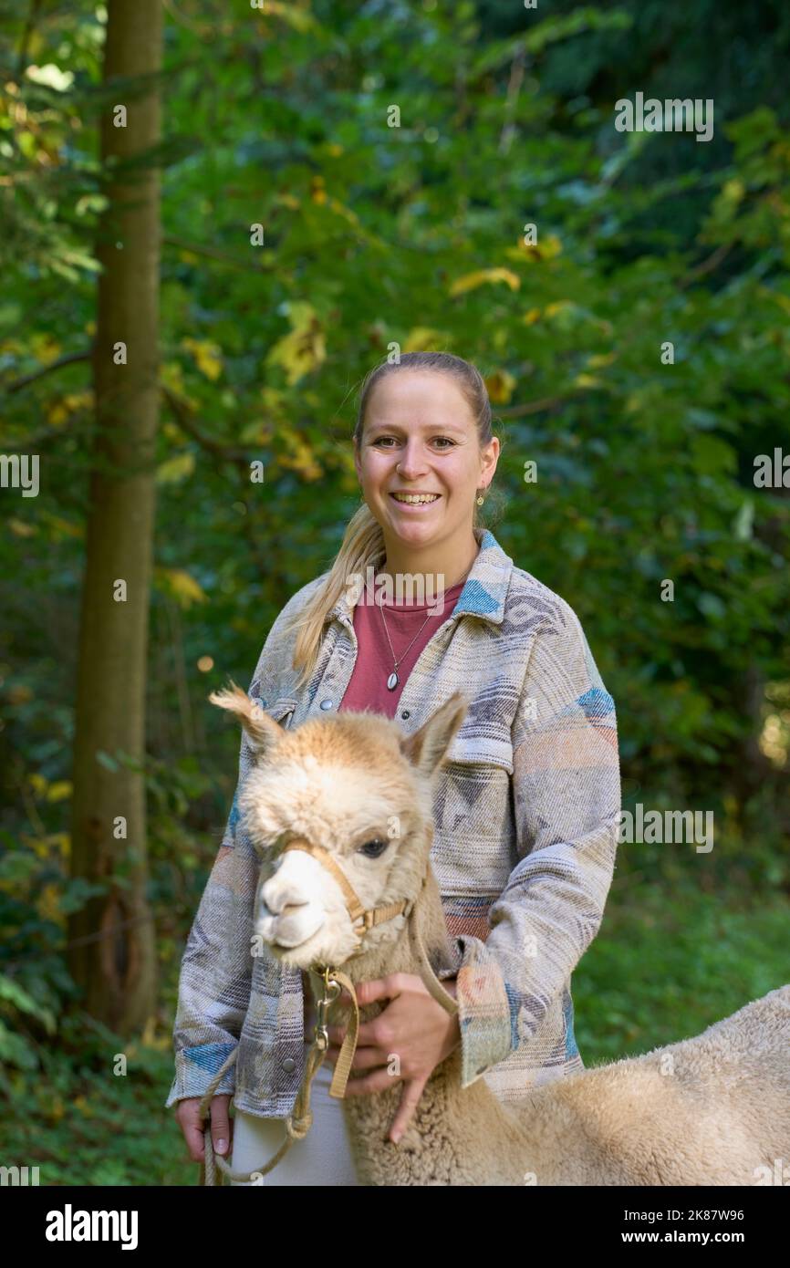 A Sunbeam Meets Young Woman With Beige Alpaca On Forest Path. In The ...