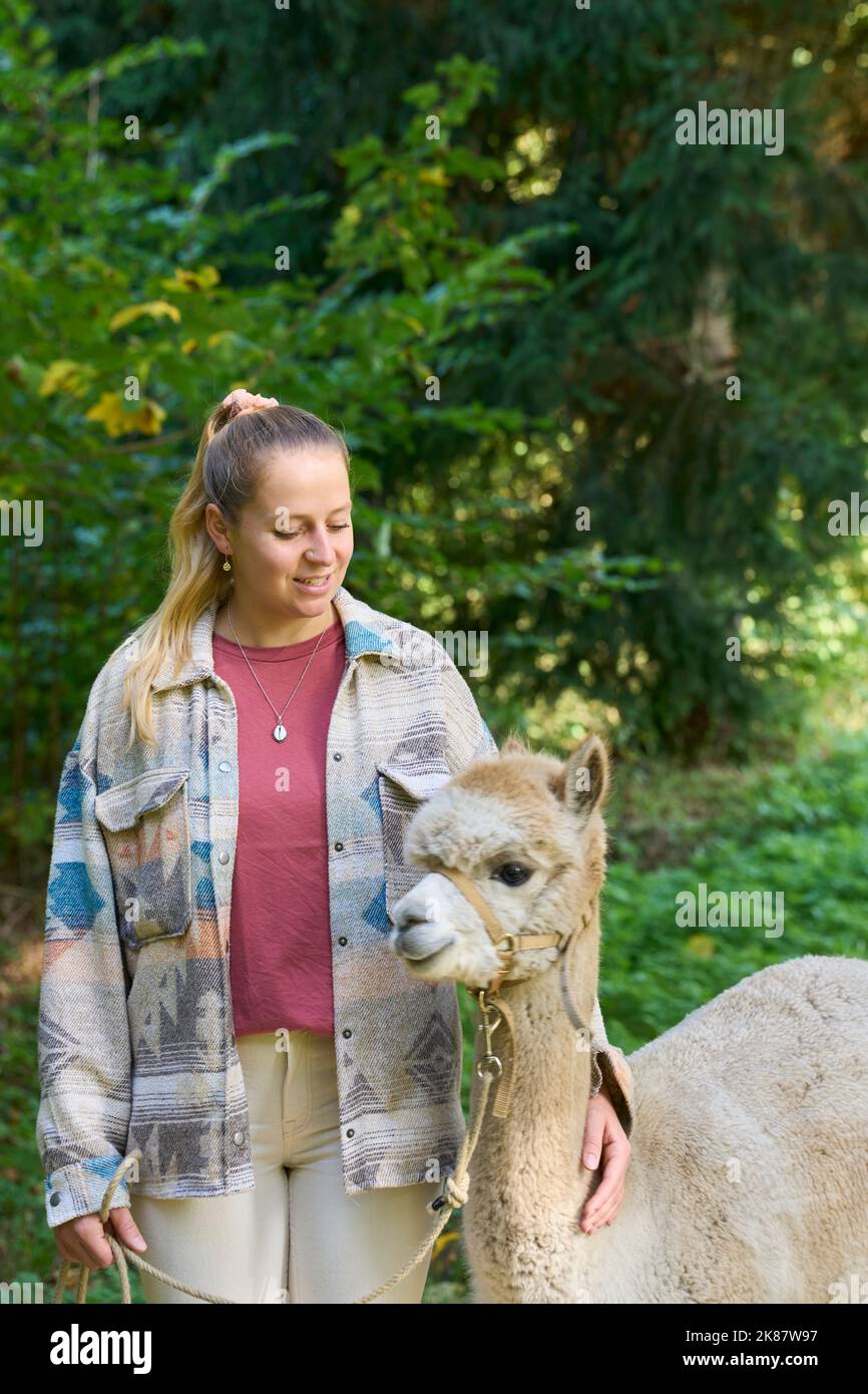 A Sunbeam Meets Young Woman With Beige Alpaca On Forest Path. In The ...