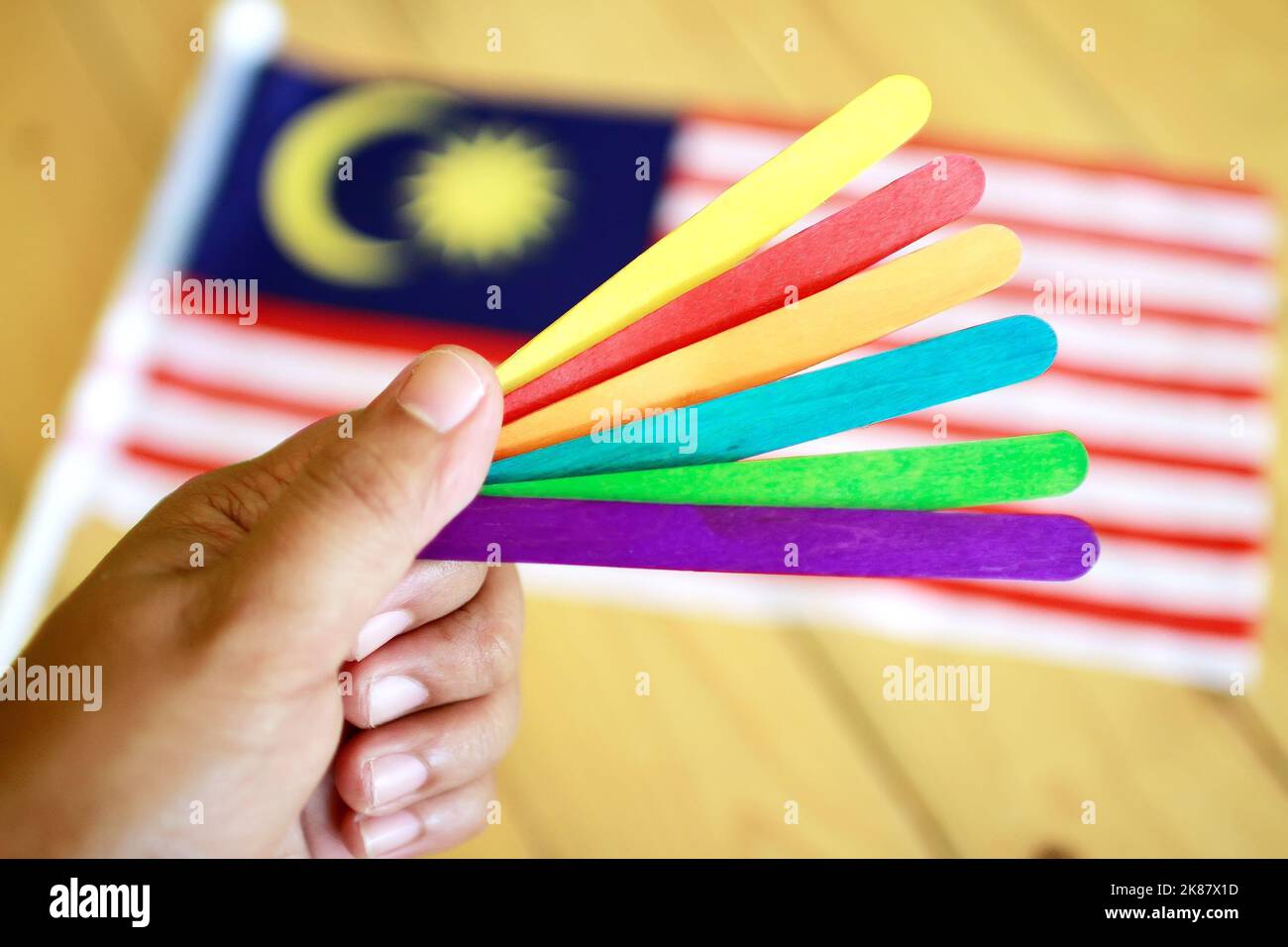 A man holding multi-colored counting sticks for children on a ...
